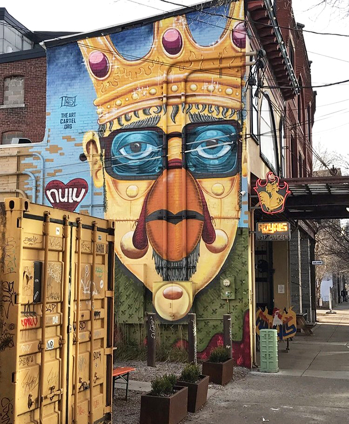 Not just a mural, but a neighborhood landmark. The king watches over his chicken kingdom with benevolent, bespectacled authority.