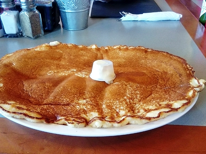 A pancake so perfectly golden and massive it deserves its own zip code &ndash; butter melting into a delicious puddle on top.