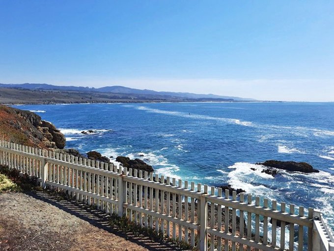 The white picket fence seems to be saying, "Please don't fall off this cliff while taking selfies," in the most charming way possible.