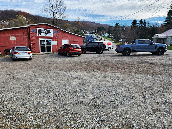 A gravel parking lot filled with vehicles of all types. Good barbecue is the great equalizer&mdash;bringing pickup trucks and sedans together in harmony.