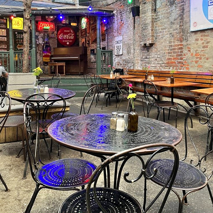 The courtyard feels like stumbling upon a secret garden party where brick walls keep the outside world at bay and string lights cast magic.