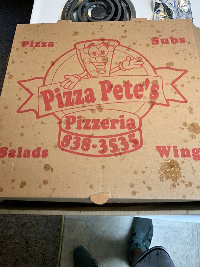 The pizza box &ndash; humble vessel of happiness, stained with the evidence of quality ingredients. That cartoon mascot knows he's delivering joy.