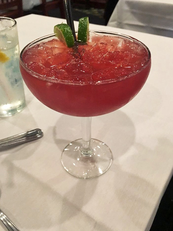 This isn't just a cocktail—it's liquid ruby, garnished with lime and promising to make whatever stories you're sharing 40% more interesting.