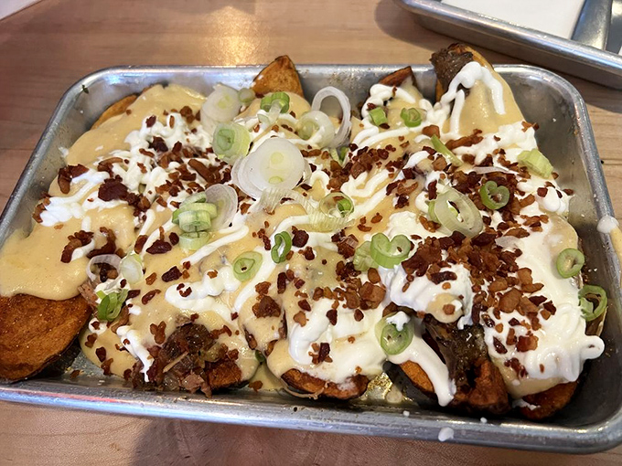 Loaded potato skins elevated to art form—cheese, bacon bits, and green onions creating a symphony of flavors in every bite.