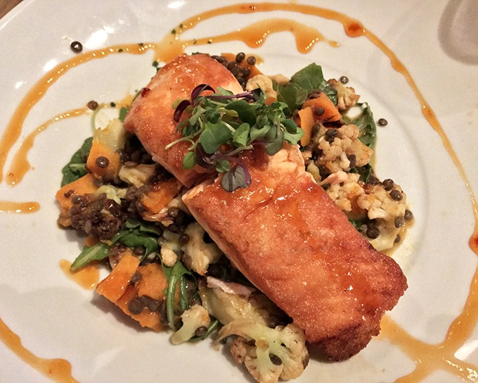 Perfectly seared fish with artistic sauce swirls &ndash; proof that some plates deserve to be in both your stomach and an art gallery.