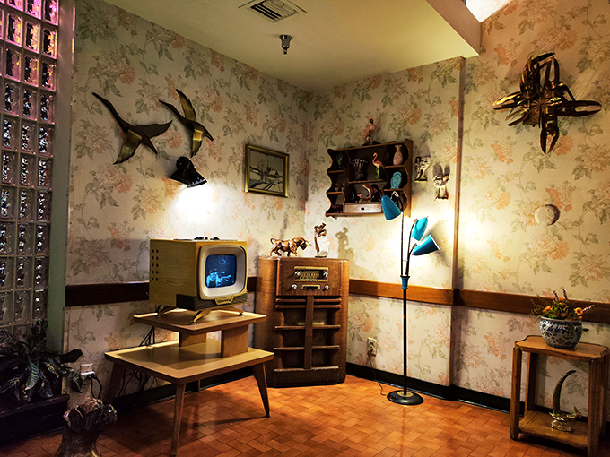 The floral wallpaper and vintage electronics corner could be a museum exhibit titled "Your Grandparents' First Apartment." The flying ducks complete the time warp.