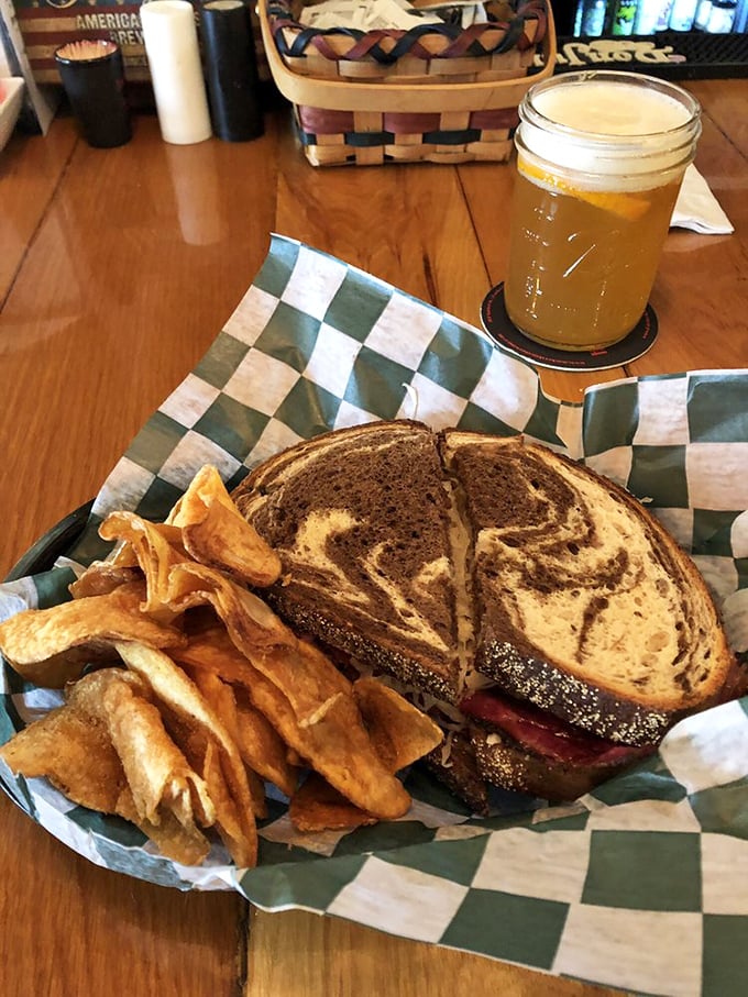 This marbled rye sandwich with house-made chips isn't just lunch &ndash; it's edible architecture. The golden beer alongside completes this midday masterpiece.