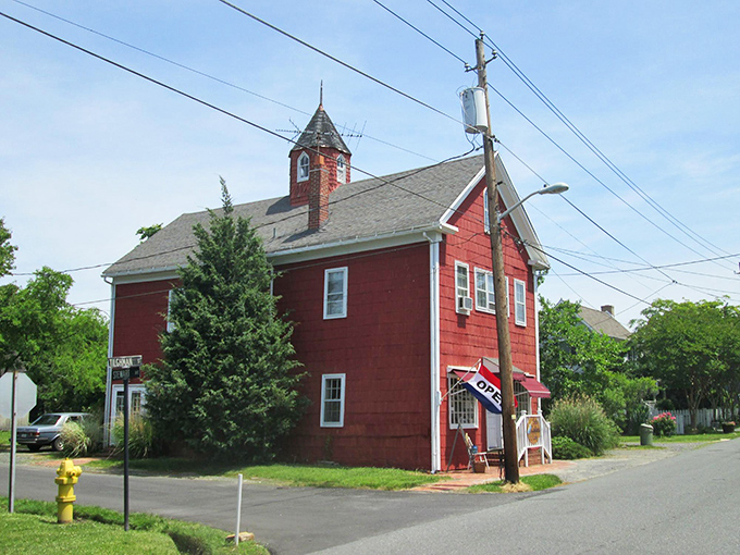 The Sea Captain's Lady stands as a cheerful sentinel in Oxford, its red siding and bell tower reminiscent of the schoolhouse where time forgot to move forward.