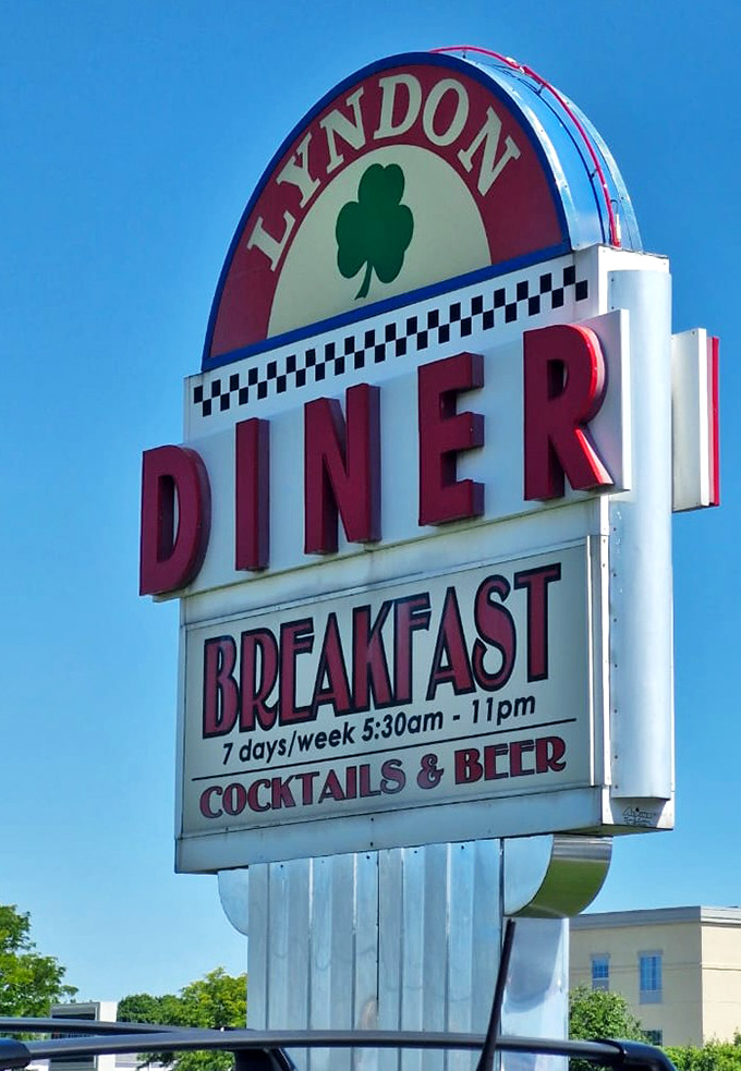 The sign tells you everything you need to know: breakfast all day, open early, and yes, they have cocktails. Some heroes wear aprons, not capes.