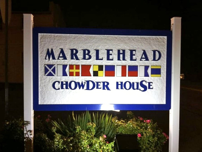 The illuminated sign that beckons seafood lovers like a lighthouse guiding hungry sailors home. Those nautical flags aren't just pretty&mdash;they're a promise. 