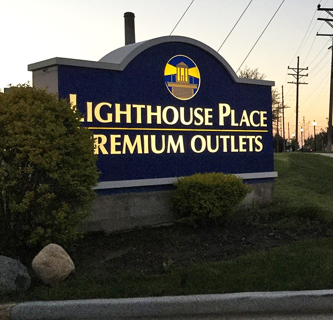 The entrance sign glows at dusk, beckoning shoppers like moths to a flame&mdash;a very fiscally responsible flame.