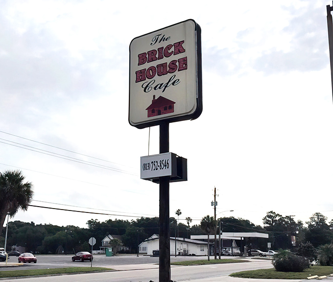 The roadside sign stands tall like a lighthouse, guiding hungry souls through the sea of chain restaurants to this authentic harbor of flavor.