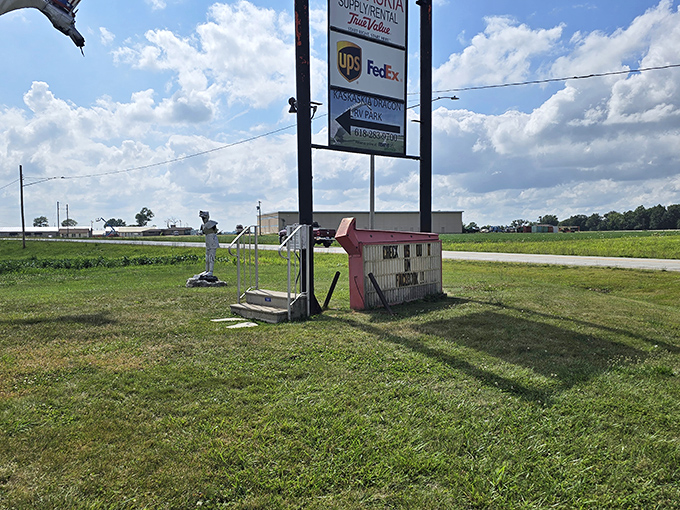 The unassuming entrance where dragon adventures begin, complete with a sign pointing visitors toward fiery entertainment.