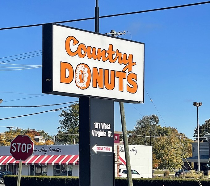 The roadside sign—a North Star for the hungry traveler. Those orange letters have guided more dawn pilgrimages than any GPS ever could.