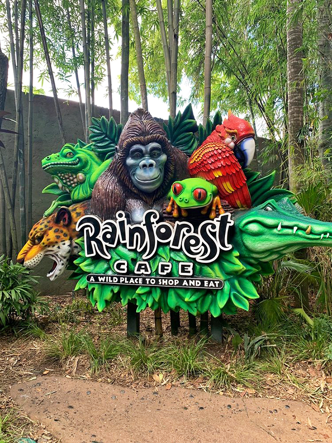 The colorful menagerie of animals on the Rainforest Cafe sign promises exactly what it delivers &ndash; "A Wild Place to Shop and Eat."