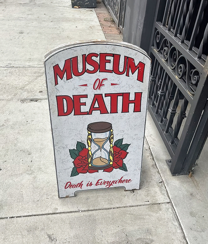 "Death is Everywhere" reminds the sidewalk sandwich board, featuring an hourglass surrounded by roses. Time waits for no one.
