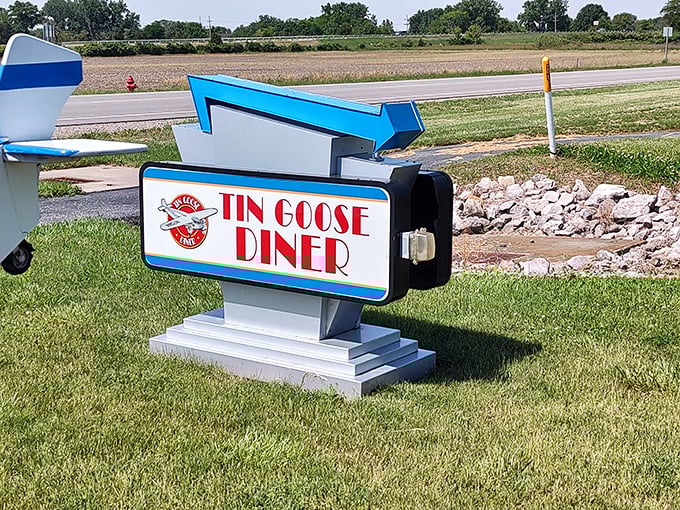 The roadside sign stands as a cheerful sentinel, guiding hungry travelers to this chrome-clad temple of breakfast delights just off the highway.