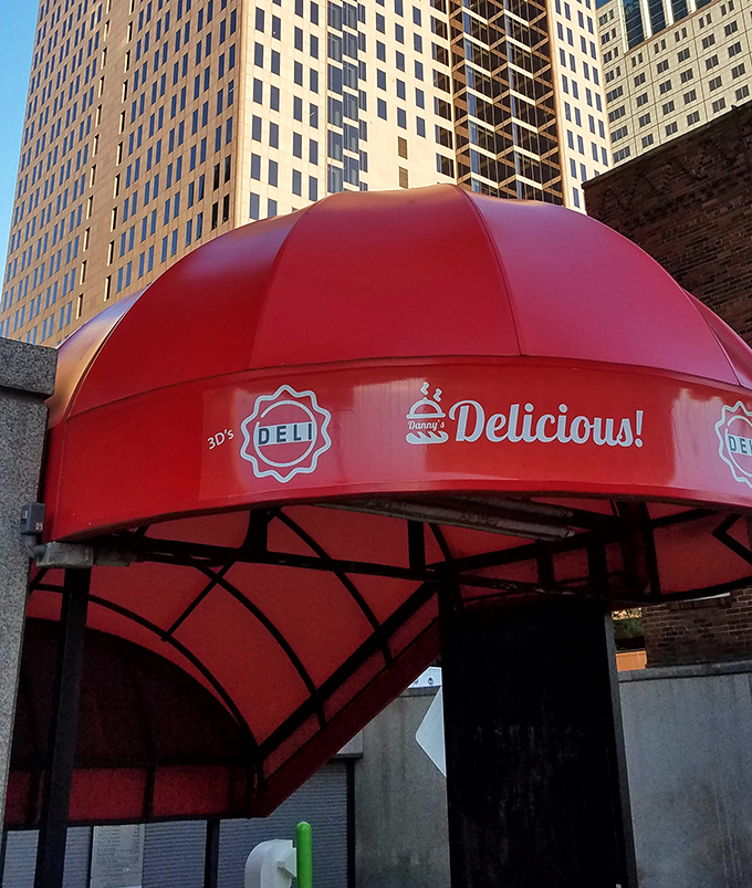 Downtown high-rises provide a dramatic backdrop for that signature red awning&mdash;a splash of color and promise in the urban landscape.