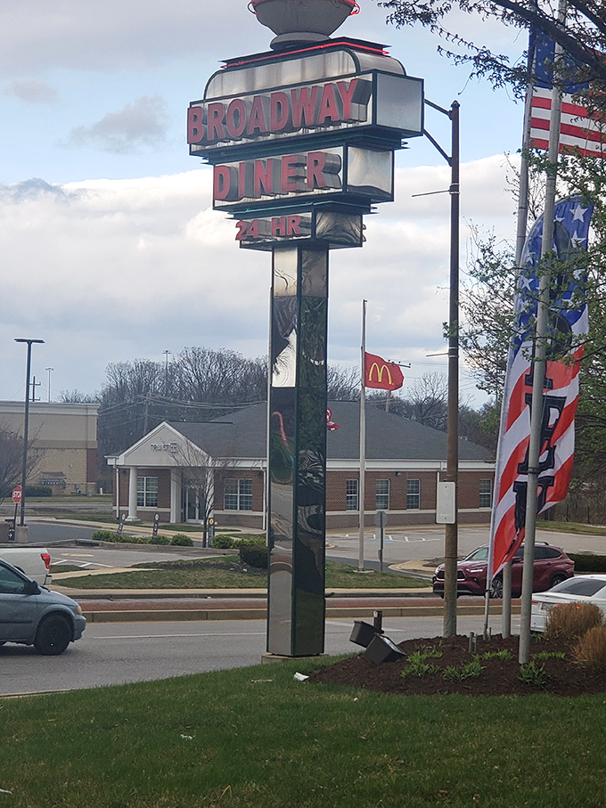 The Broadway Diner sign stands tall against the Maryland sky, a sentinel of sustenance that's been guiding hungry travelers for generations.