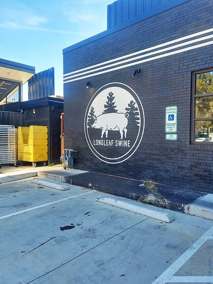 The iconic logo on black brick &ndash; two trees and a pig that tell you everything you need to know about Longleaf's commitment to place and plate.