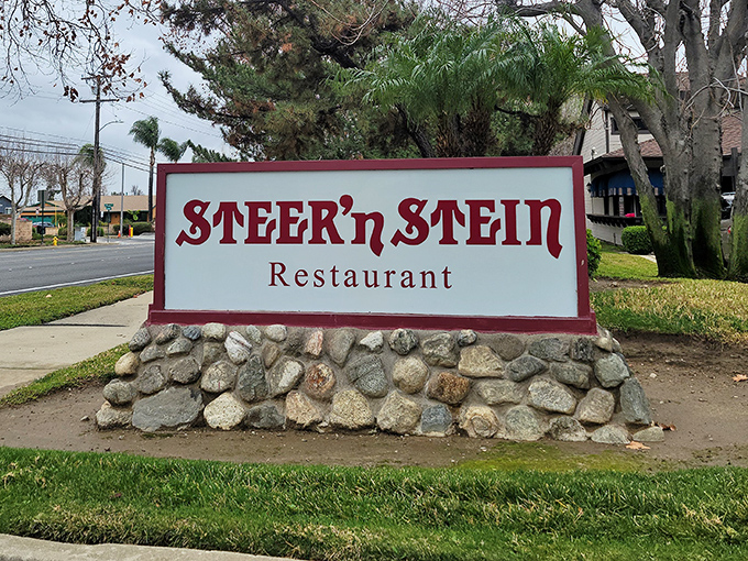 The roadside sign, perched atop a bed of river rocks, stands as a beacon for hungry travelers and locals alike&mdash;simple, direct, and promising satisfaction.
