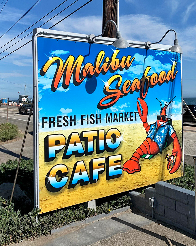 The roadside sign promises exactly what awaits: fresh seafood, casual patio dining, and that iconic lobster mascot welcoming all comers.