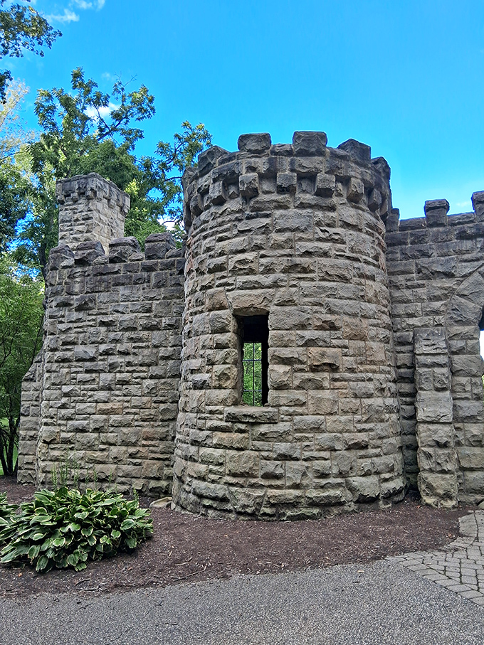 The castle's turret stands sentinel against blue skies, its crenellated top ready for archers who never arrived but tourists who certainly did.
