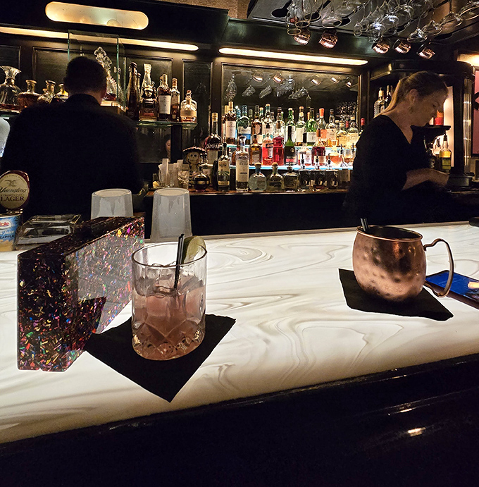 The bar's marble countertop gleams under perfect lighting, while copper mugs and crystal glasses await their starring roles in your evening's narrative.