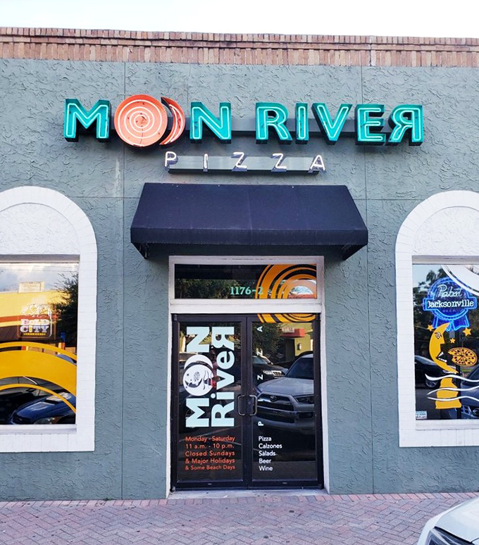 The neon sign glows like a beacon for pizza lovers. Moon River's storefront promises a wider, more colorful world inside.