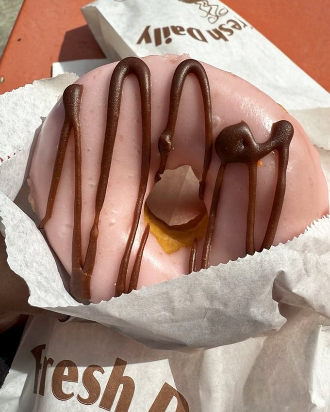 This strawberry glazed donut with chocolate drizzle is wearing its Sunday best. Dressed to impress but doesn't stand a chance of surviving the ride home.