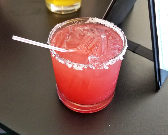 A vibrant strawberry margarita with salt-kissed rim &ndash; because sometimes the perfect seafood dinner deserves a sunset in a glass.