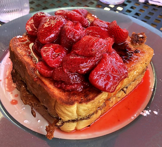 French toast that's having an identity crisis as dessert, topped with strawberries so fresh they're practically introducing themselves to your taste buds.