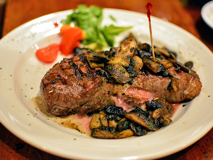 A steak topped with mushrooms that makes vegetarians question their life choices. That perfect medium-rare center is the stuff of carnivorous dreams.