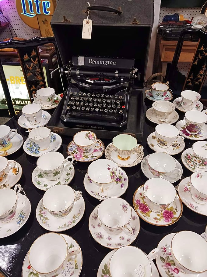 A vintage Remington typewriter holds court among delicate teacups. This juxtaposition of masculine utility and feminine elegance creates an unexpectedly perfect still life.