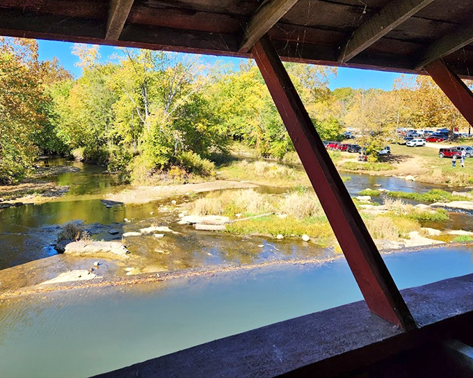 The view from inside the bridge reveals the creek's gentle flow and autumn foliage&mdash;nature's way of showing off while you're already impressed. 
