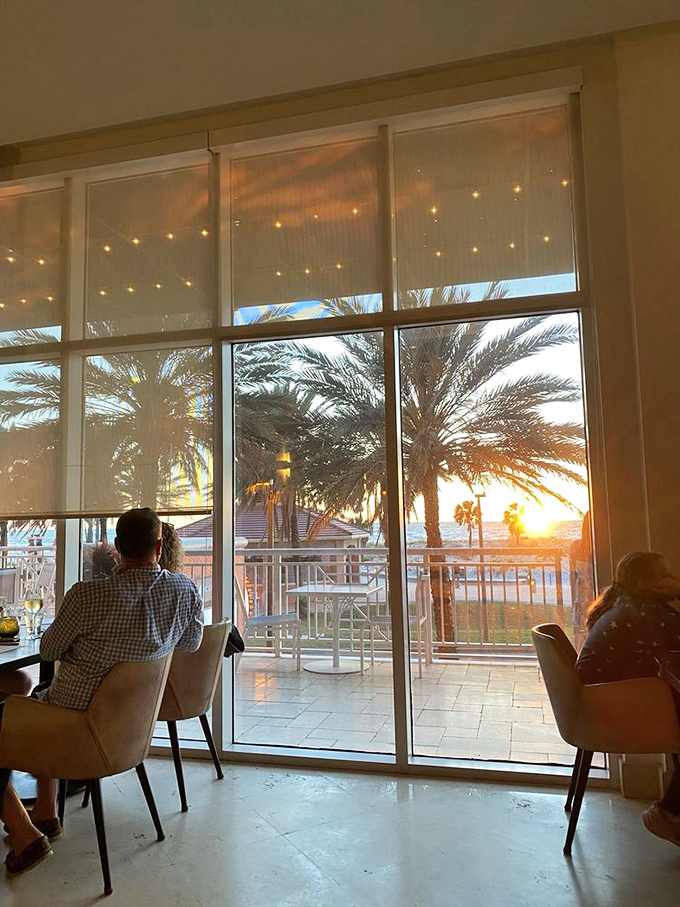 As the sun sets through floor-to-ceiling windows, diners are treated to a Florida light show that no amount of money could stage—nature's perfect dinner entertainment.