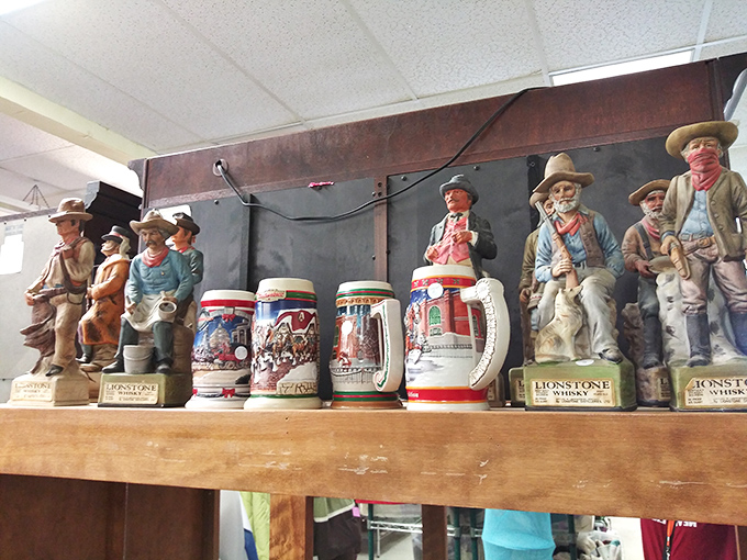 Cowboys and beer steins share shelf space in perfect thrift store harmony. These collectibles represent someone's treasured memories, now awaiting new homes. 