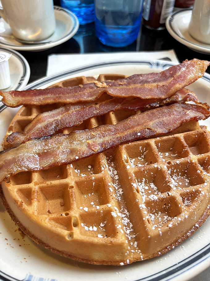 Golden waffle perfection topped with crispy bacon - because some indulgences are absolutely worth it.