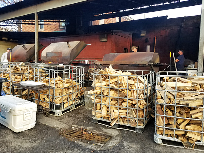 Wood stacked like treasure, waiting to become the aromatic smoke that transforms ordinary meat into extraordinary memories.