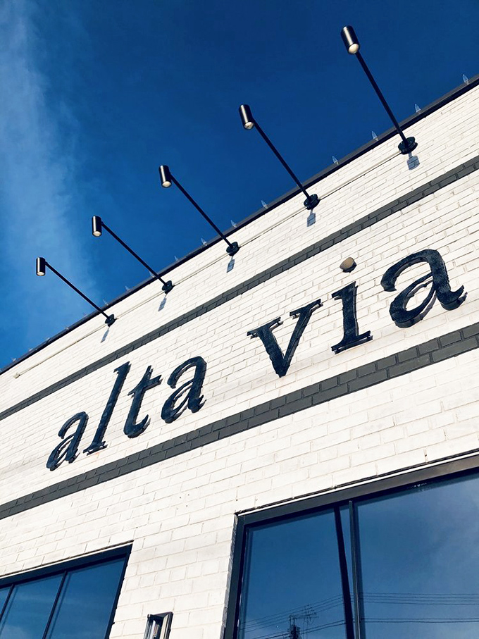 Against a perfect blue sky, Alta Via's signage stands as a beacon for food lovers—simple, confident, and promising delicious adventures within.