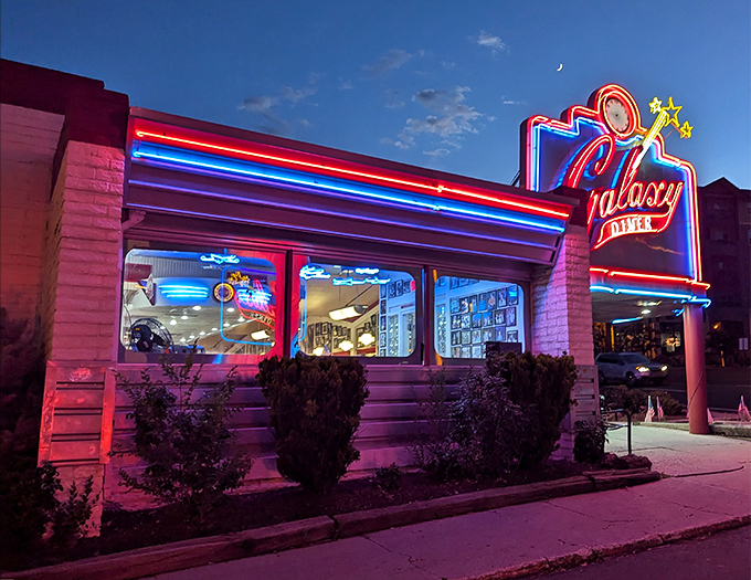 At night, Galaxy Diner transforms into a neon-drenched dream, glowing like a spaceship that landed on Route 66 and decided to serve up the best milkshakes in the galaxy.