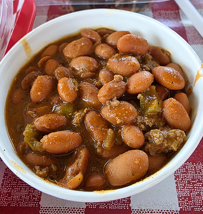 These aren't just baked beans; they're tiny legumes that have won the lottery by swimming in a sauce that's been enhanced by smoky BBQ drippings.