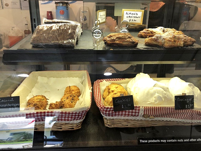 The pastry case stands as a glass-enclosed museum of temptation, where cookies and croissants compete for your attention and willpower goes to die.