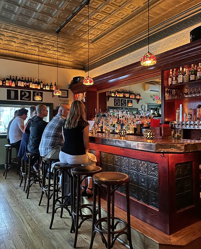 The bar area beckons with bottles that tell stories of Italian vineyards, while patrons perch on stools awaiting liquid happiness.
