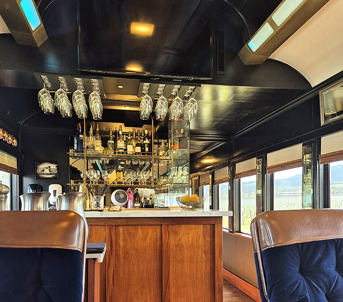 The train's bar car&mdash;where hanging glassware catches the light like crystal chandeliers and every bottle tells a story worth hearing.