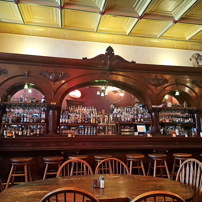 The bar where legends were born and whiskey flowed&mdash;ornate woodwork frames bottles that promise stories with every pour.