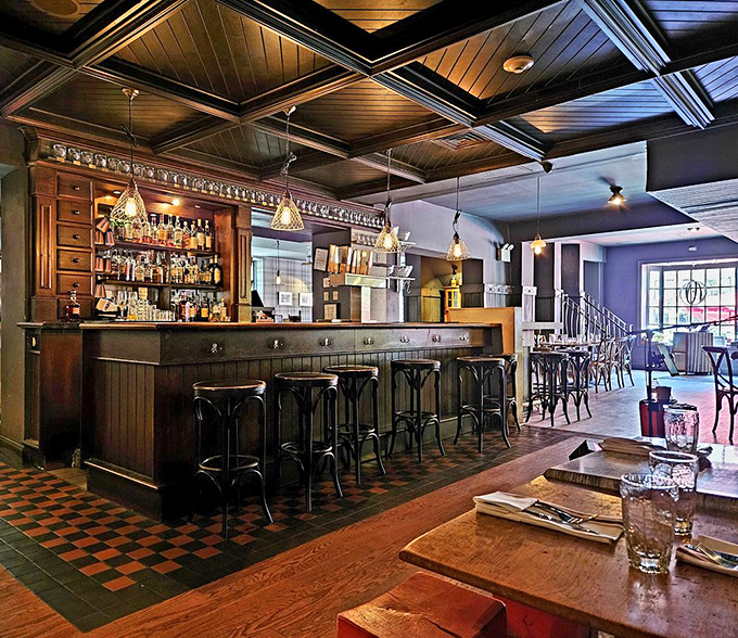 The bar at The Twisted Tail isn't just a place to order drinks—it's a bourbon sanctuary where whiskey dreams come true under a gorgeous coffered ceiling.