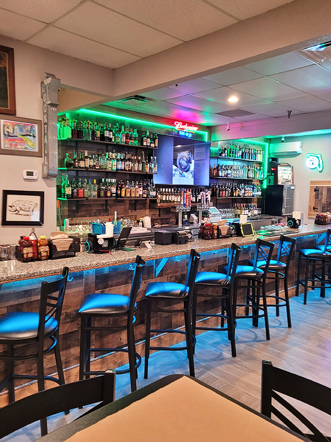 The bar area glows with promise, offering liquid companions for your barbecue journey. Those blue chairs aren't just seating; they're front-row tickets to flavor town.