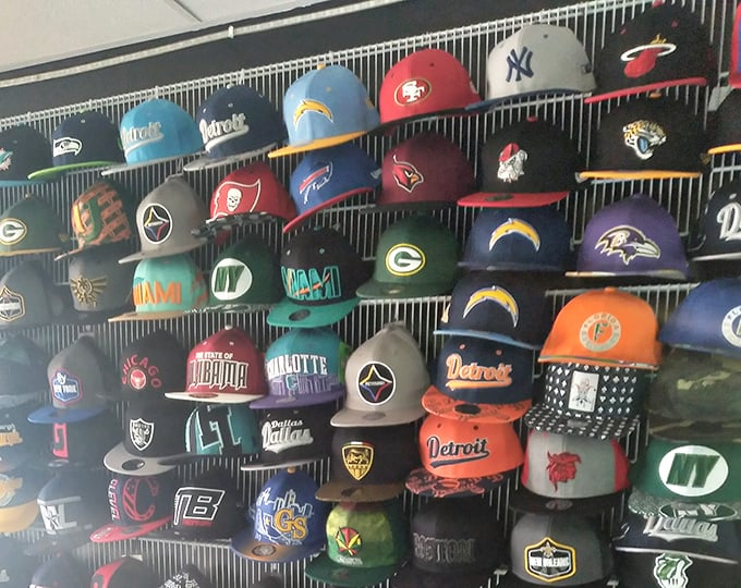 Sports fans unite! This wall of team caps represents fierce rivalries hanging peacefully side by side&mdash;until they're worn out into the world.