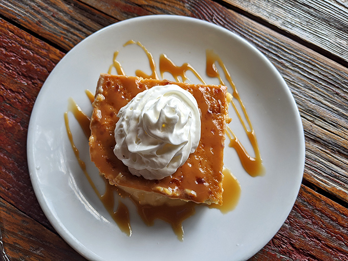 Bread pudding draped in caramel with a cloud of whipped cream on top. The kind of dessert that makes you consider skipping dinner next time.